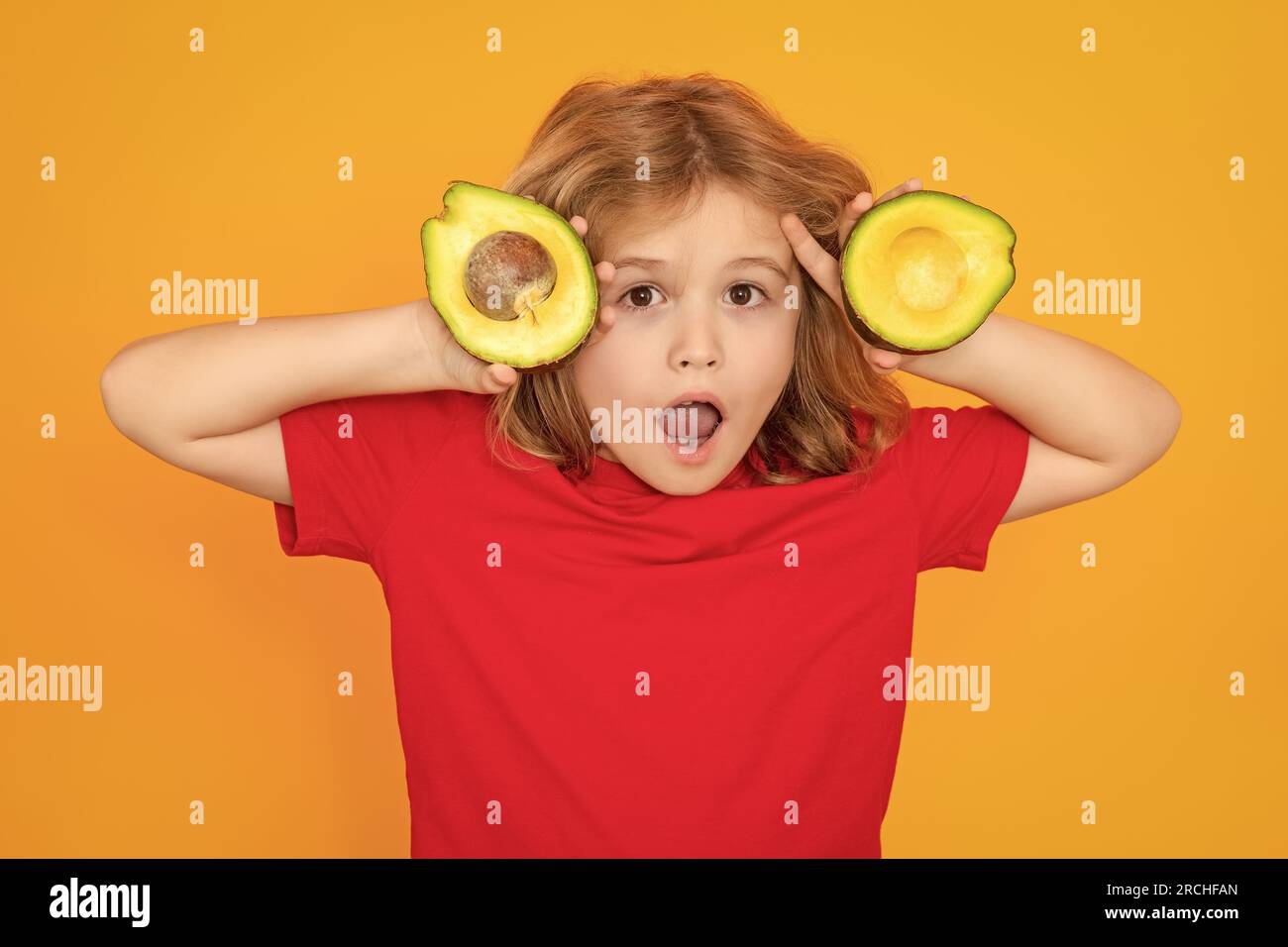 Healthy fruits and vegetables for kids. Kid hold red avocado in studio ...