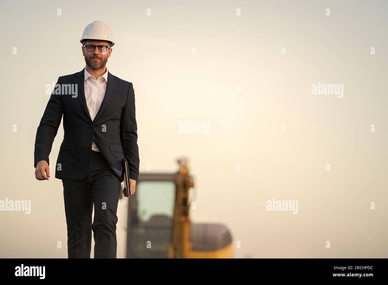 Construction owner near excavator. Confident construction owner in ...