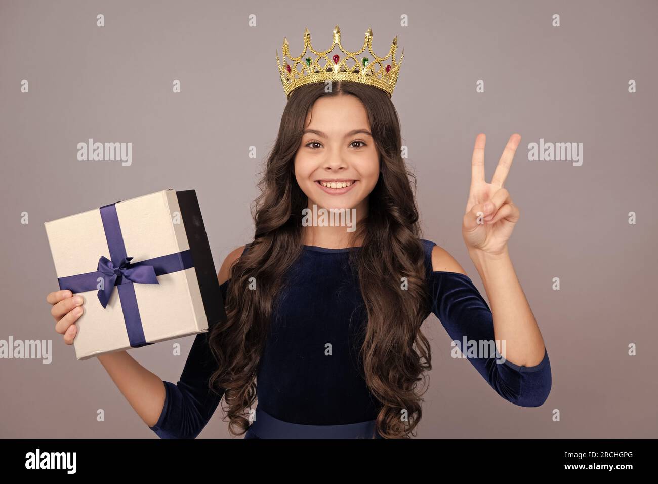 Teenager kid with present box. Teen girl princess in crown giving ...