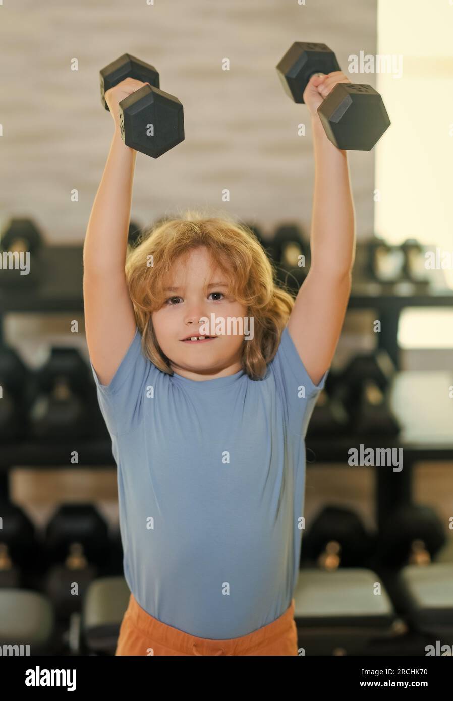 Child boy pumping up biceps muscles with dumbbell. Fitness kids with dumbbells Stock Photo - Alamy