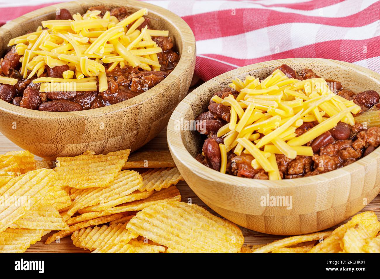 A wooden bowl of delicious Chili with Cheddar Cheese and Chips Stock ...