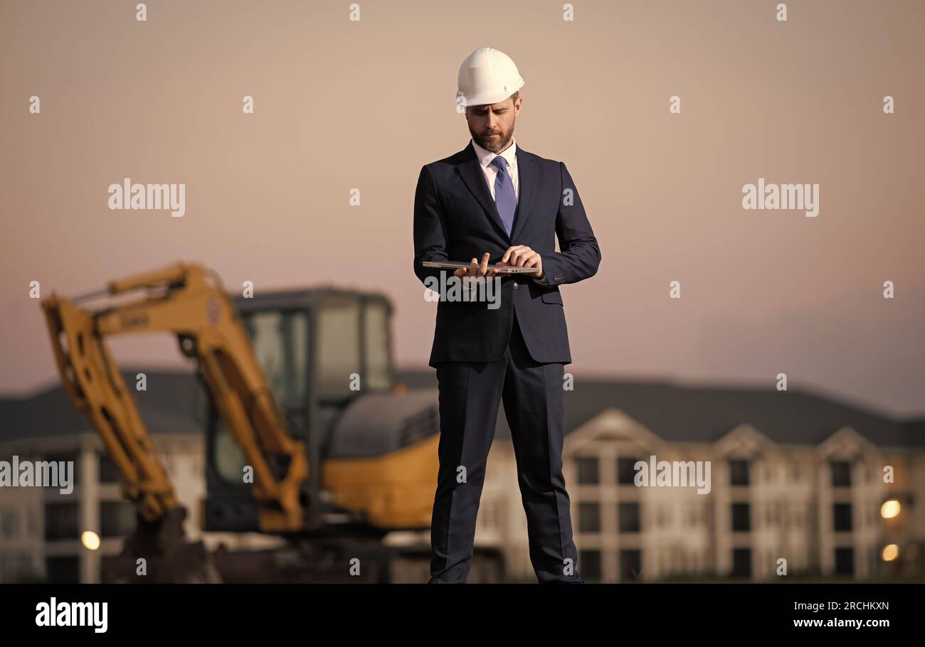 Architect at a construction site. Architect man in helmet and suit at ...