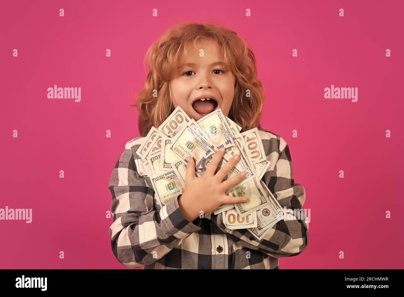 Child with lots of money dollar banknotes isolated over pink red studio ...