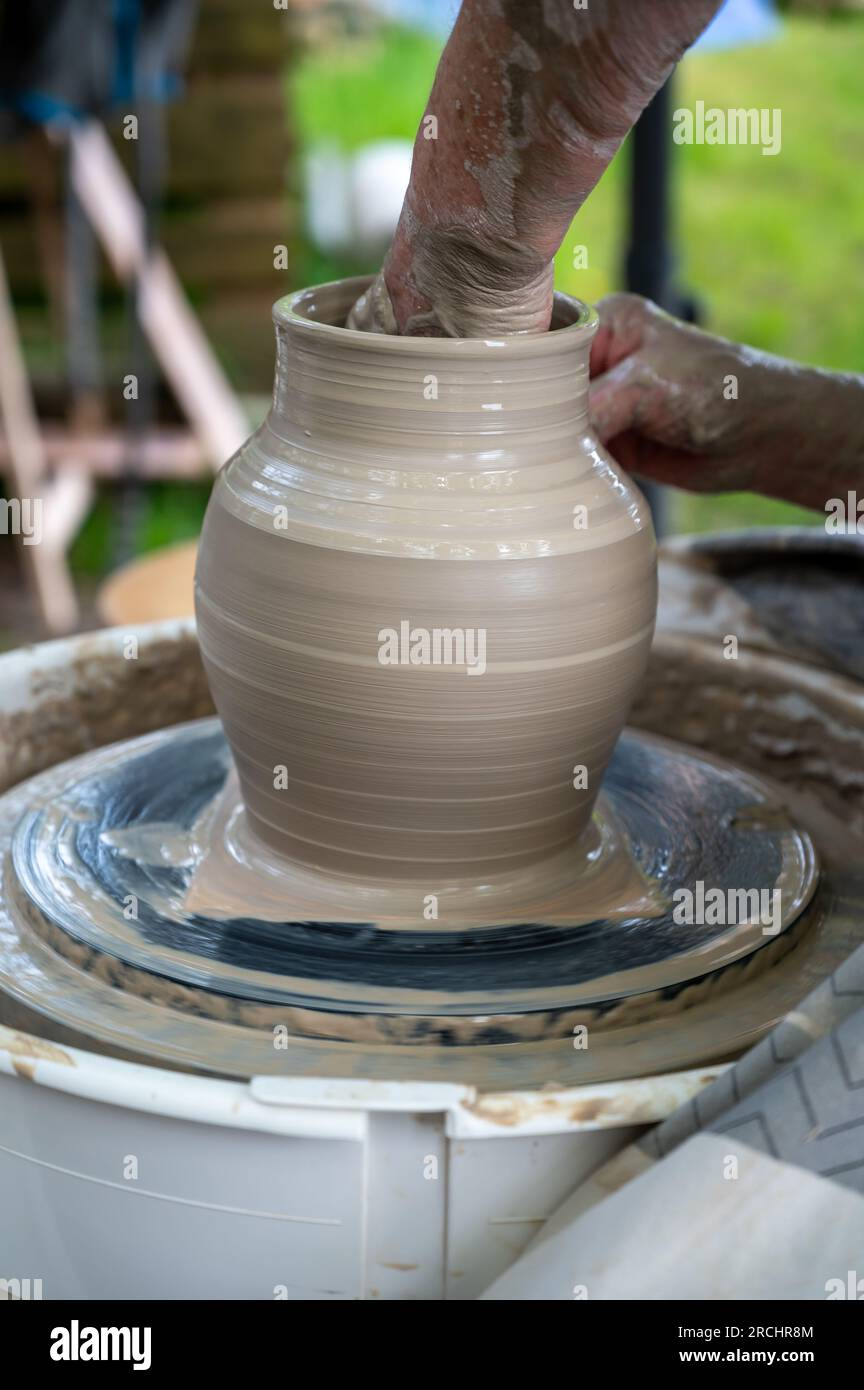 Making of mud pot on potters wheel during workshop outdoor in ...