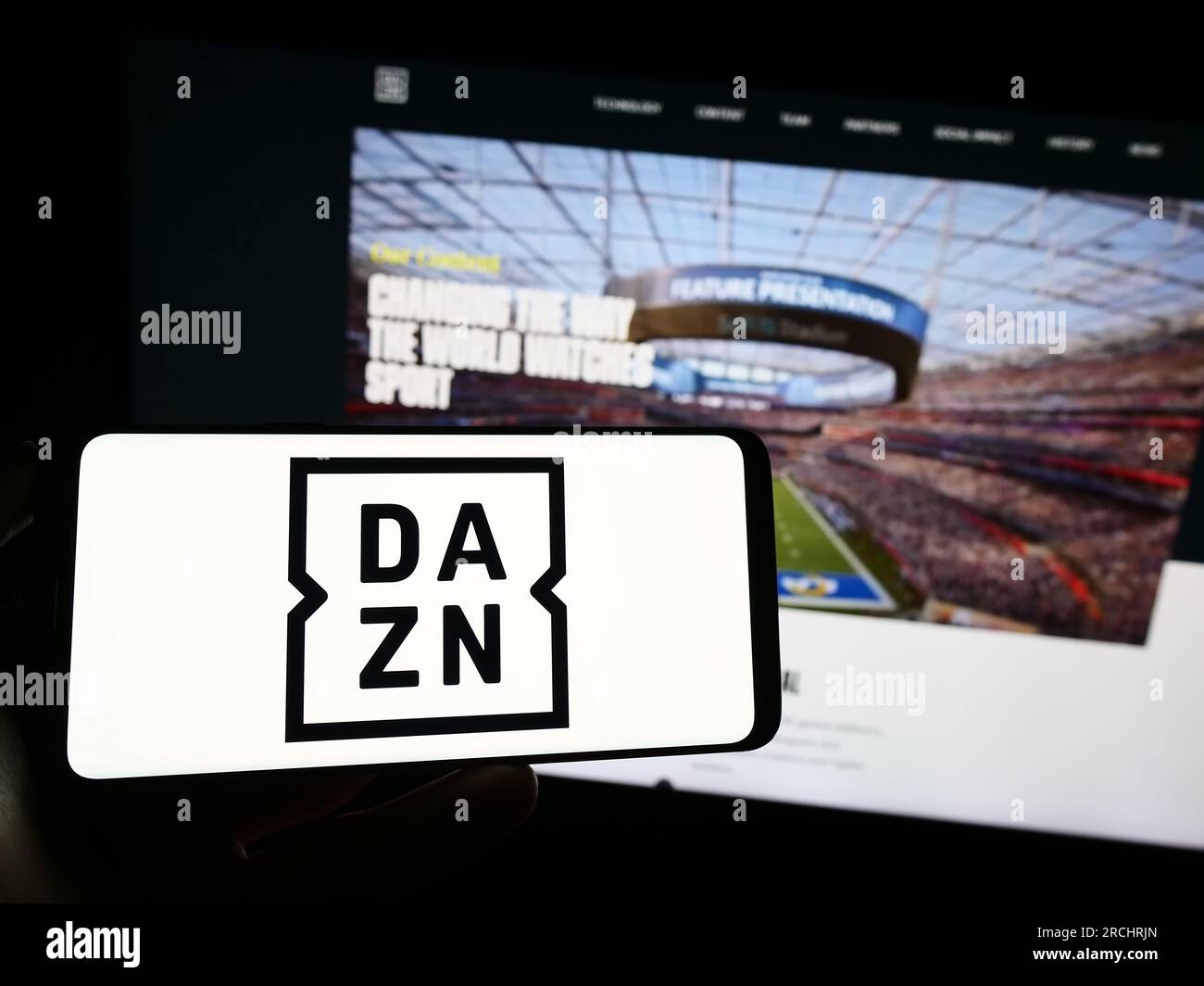 Person holding cellphone with logo of British sports media company DAZN ...