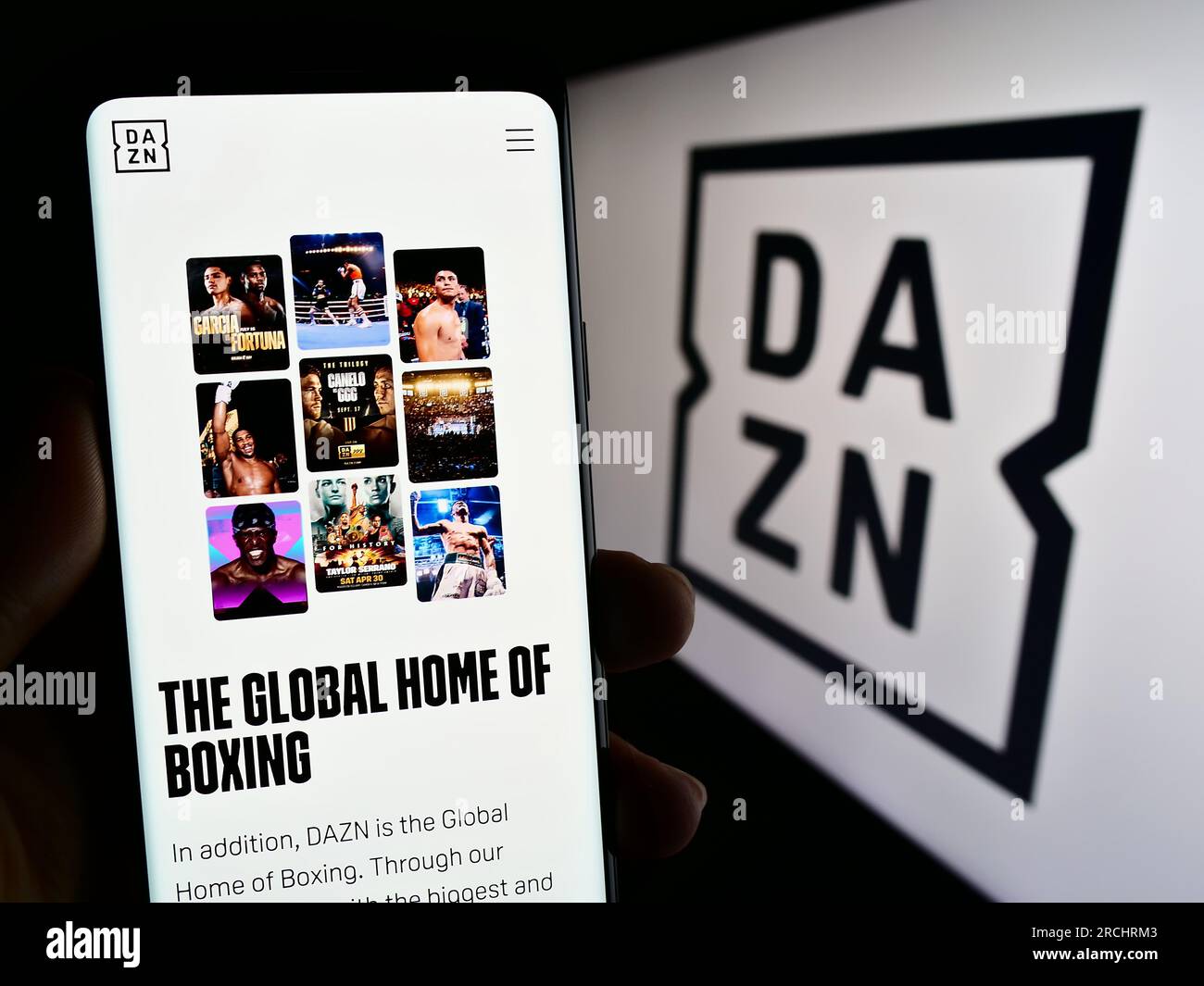 Person holding smartphone with web page of British sports media company DAZN Group Limited on ...