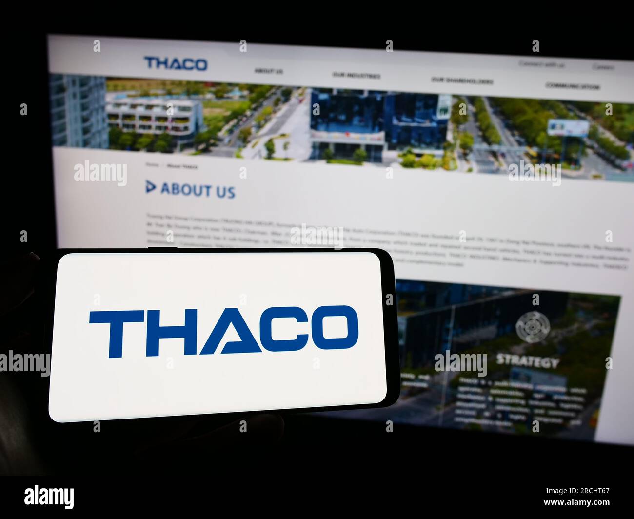 Person holding mobile phone with logo of company Truong Hai Auto ...