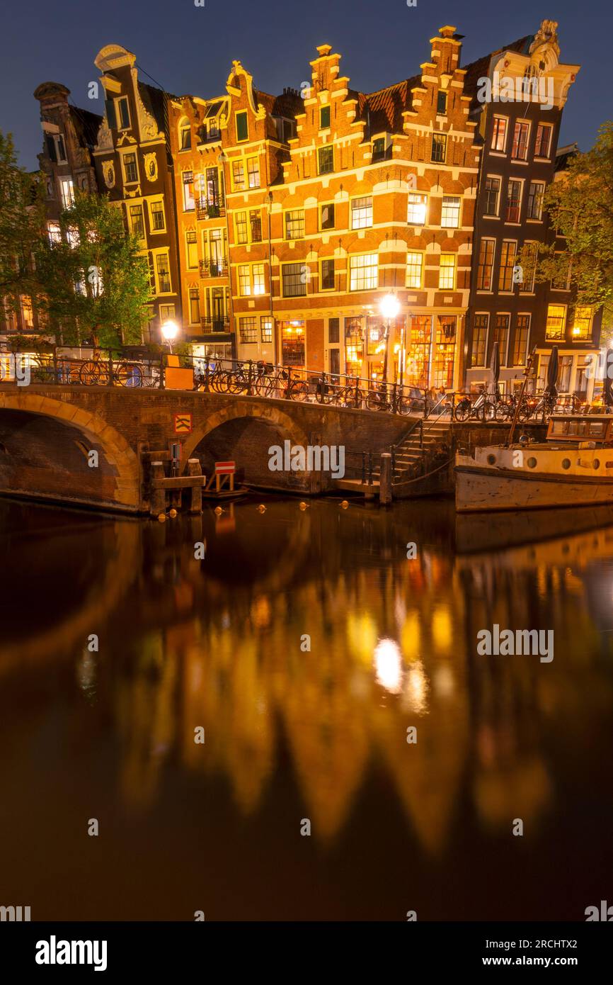 Netherlands. Night on the canal of Amsterdam. Dancing Dutch houses with ...