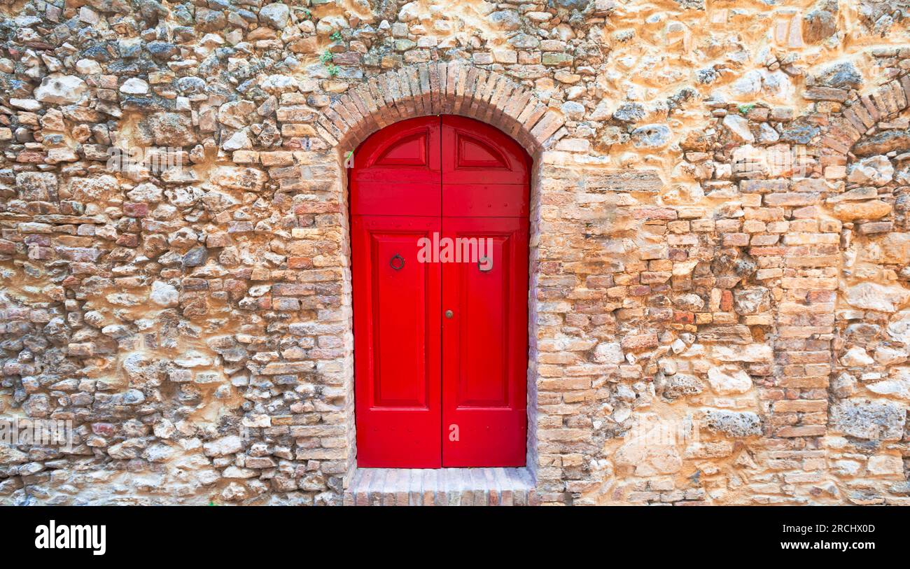 Traditional wooden door, vibrant red color, medieval walls, San ...