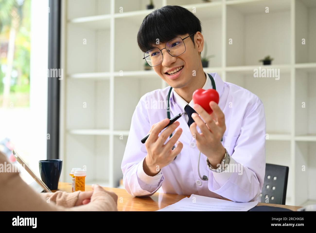 Cardiologist in white uniform giving a consultation to female patient ...