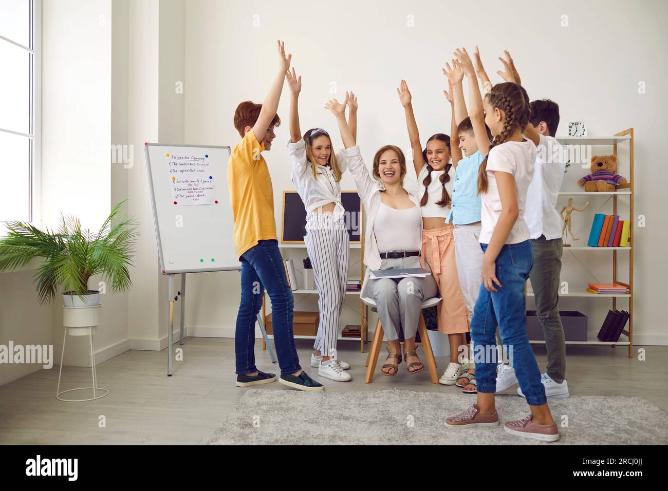 Happy teacher and elementary school students having fun during lesson ...