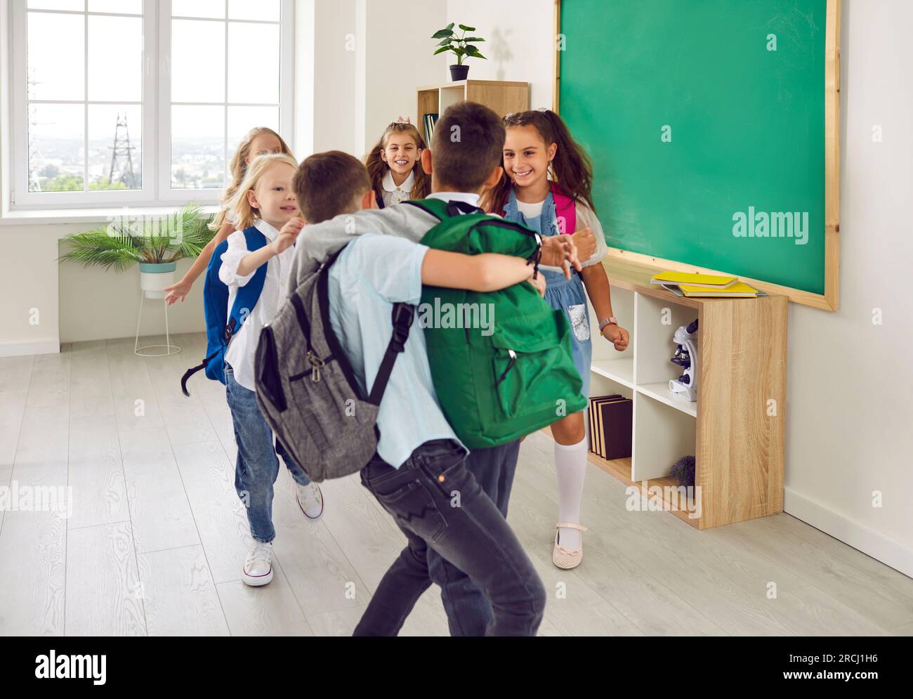 Happy school children having fun and playing in classroom at school ...