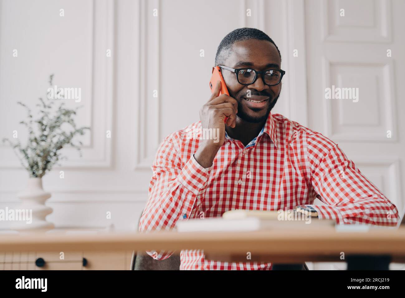 Smiling African American businessman consulting client, talking on ...