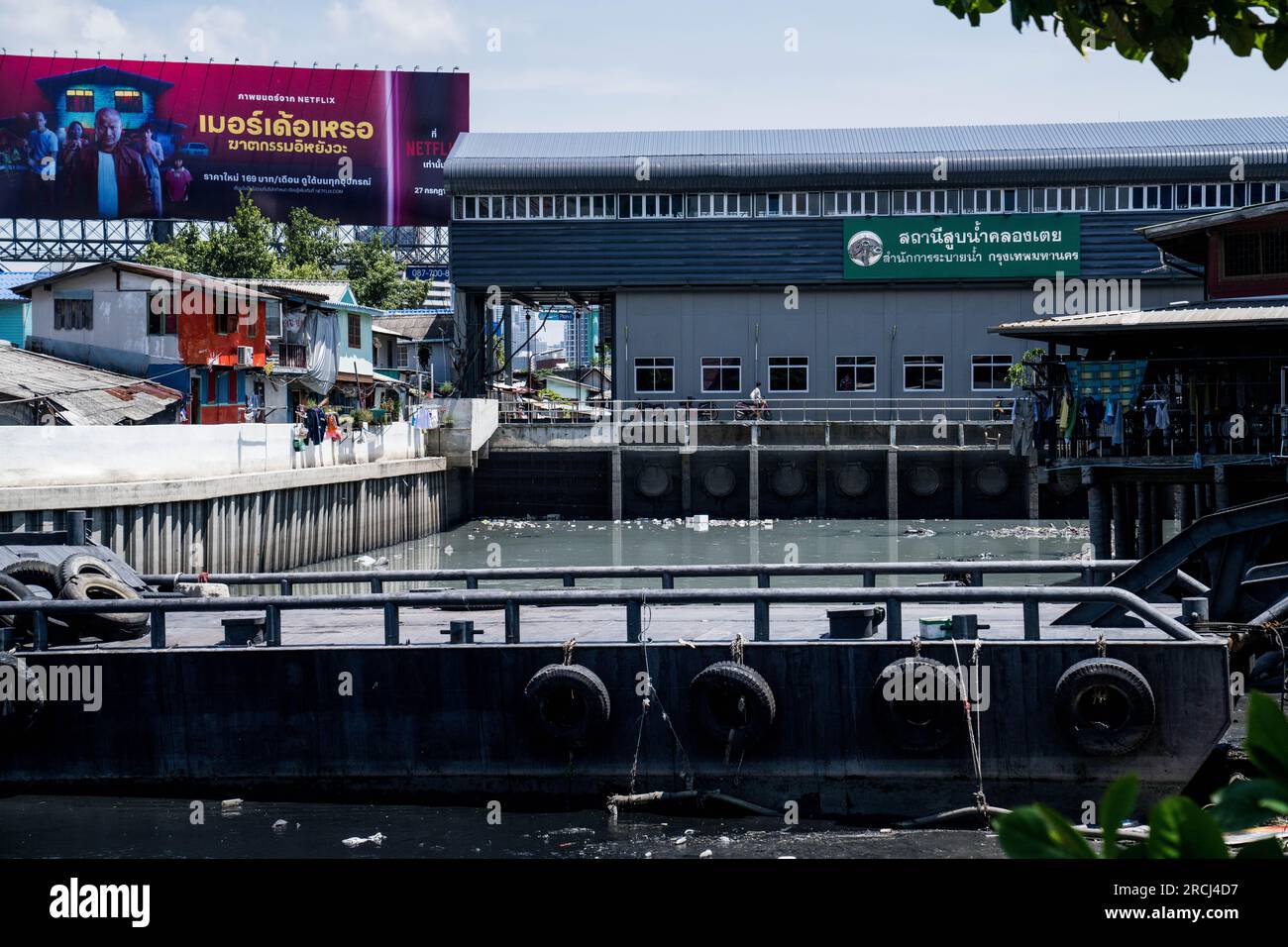 Bangkok, Thailand. 15th July, 2023. People walk on a path over a canal ...