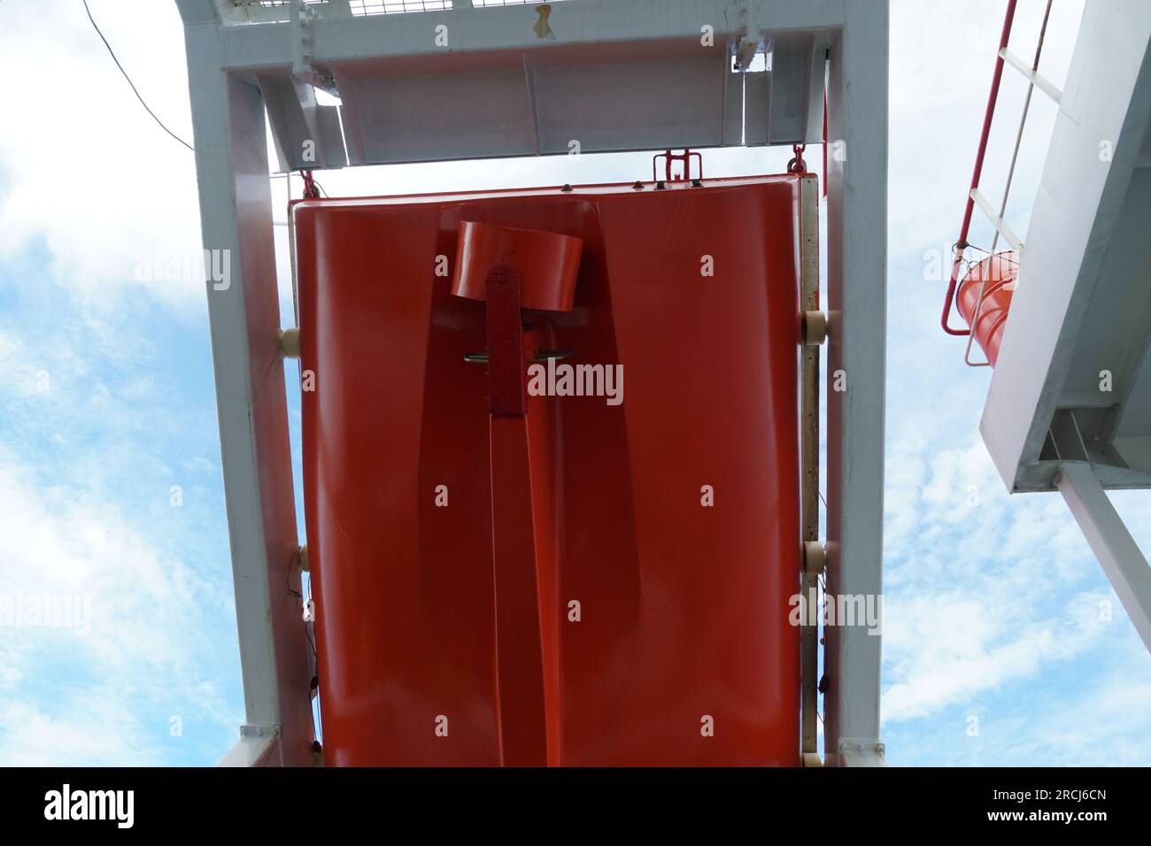 Orange free fall life boat secured in launching ramp is viewed from ...