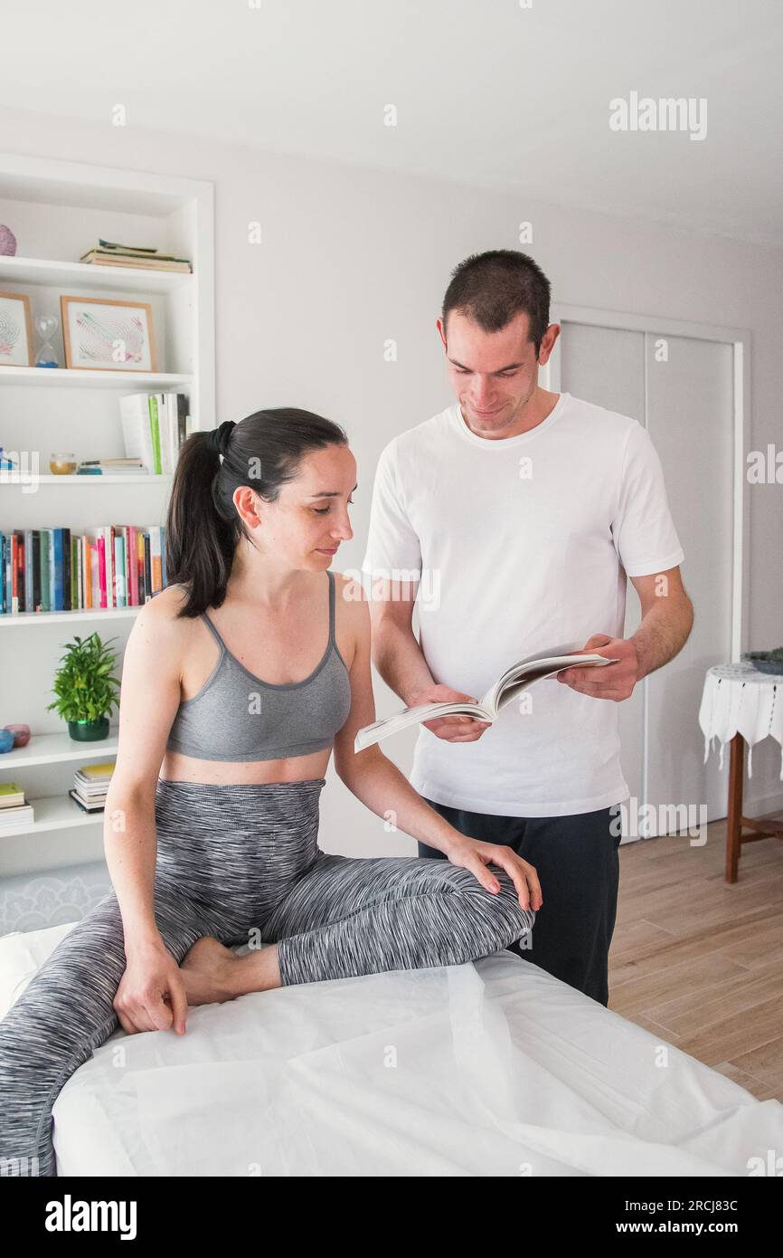 Therapist showing a book to a patient in a moment of relaxation after ...
