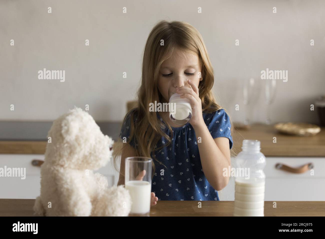 Pretty adorable preschool girl drinking milk in home kitchen Stock ...