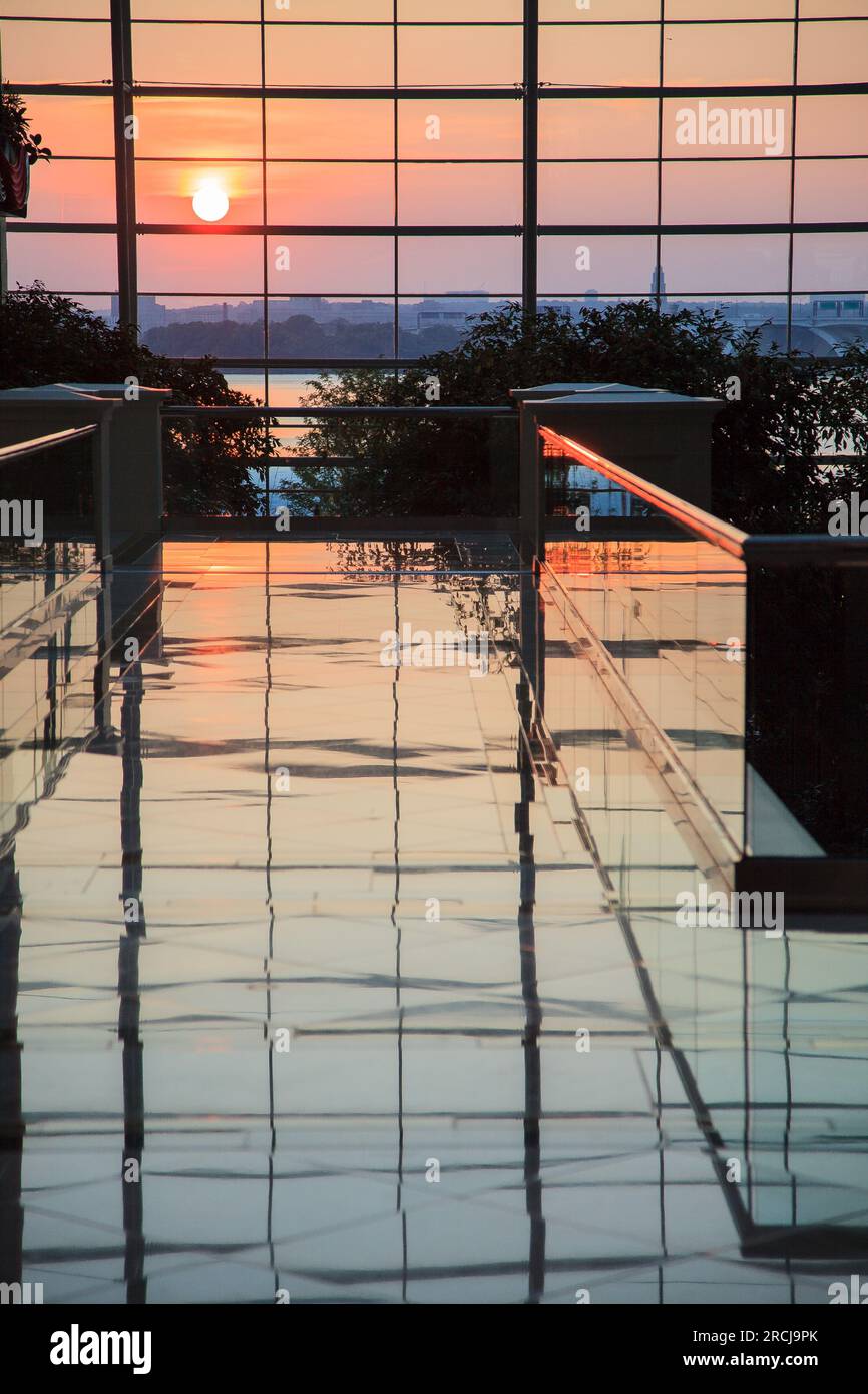 Shot of a sunset through a large glass building facade and ...