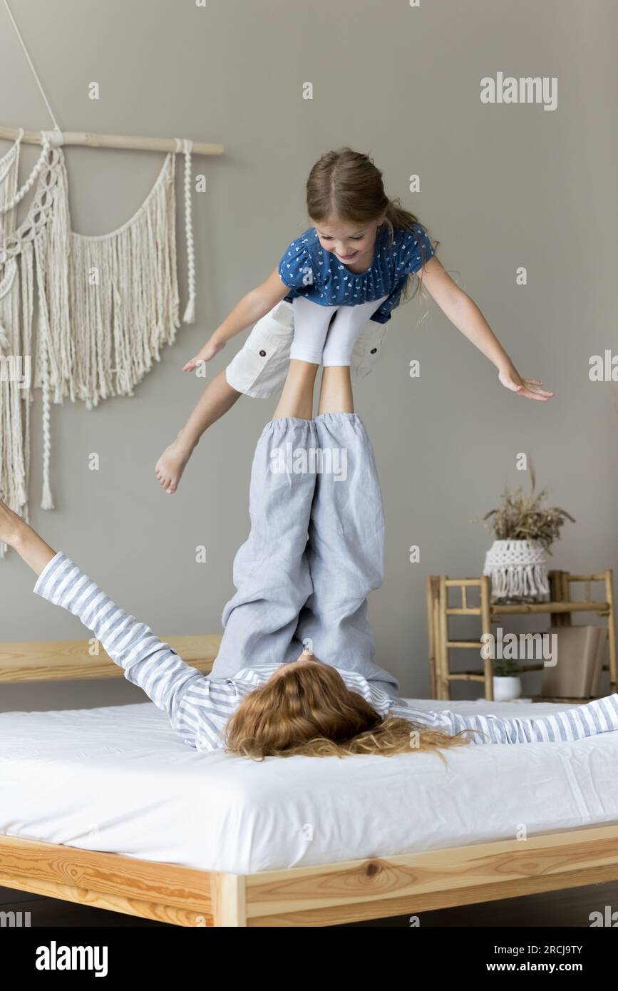Active strong mother lifting kid in air on feet Stock Photo - Alamy