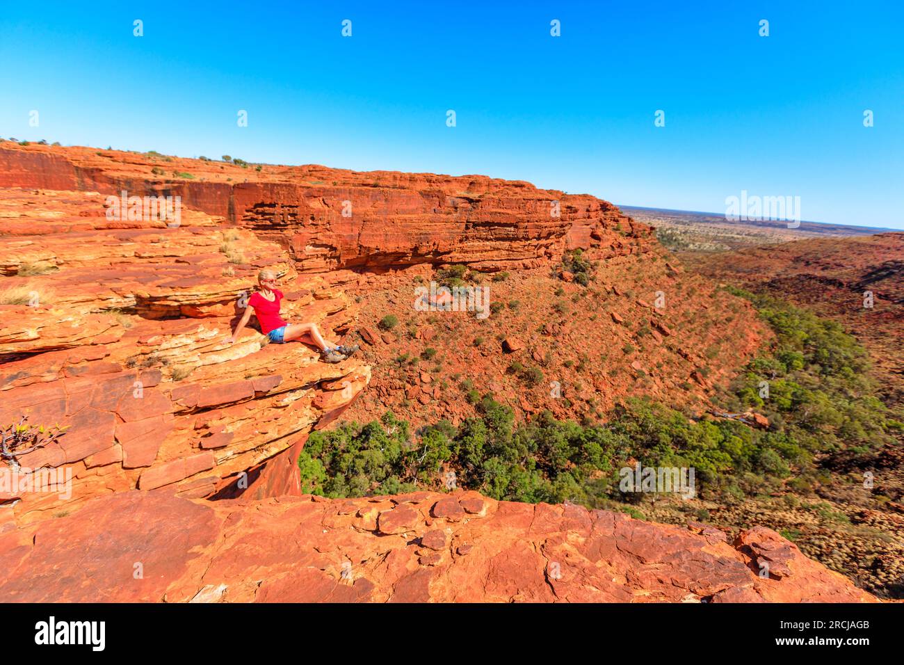 tourist girl sitting on the edge of Kings Canyon in Watarrka National ...