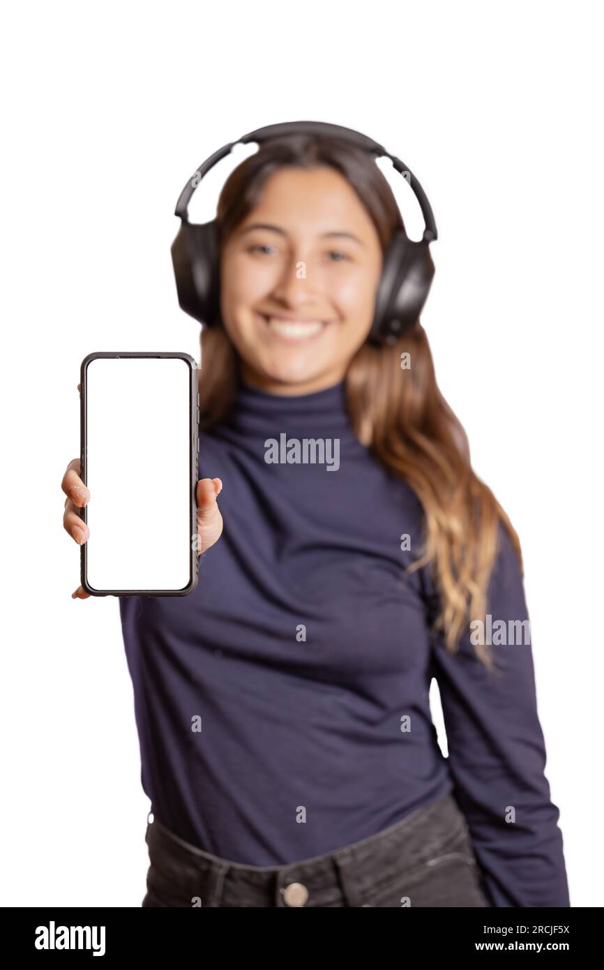 Latin girl with headphones out of focus shows the blank screen of her ...