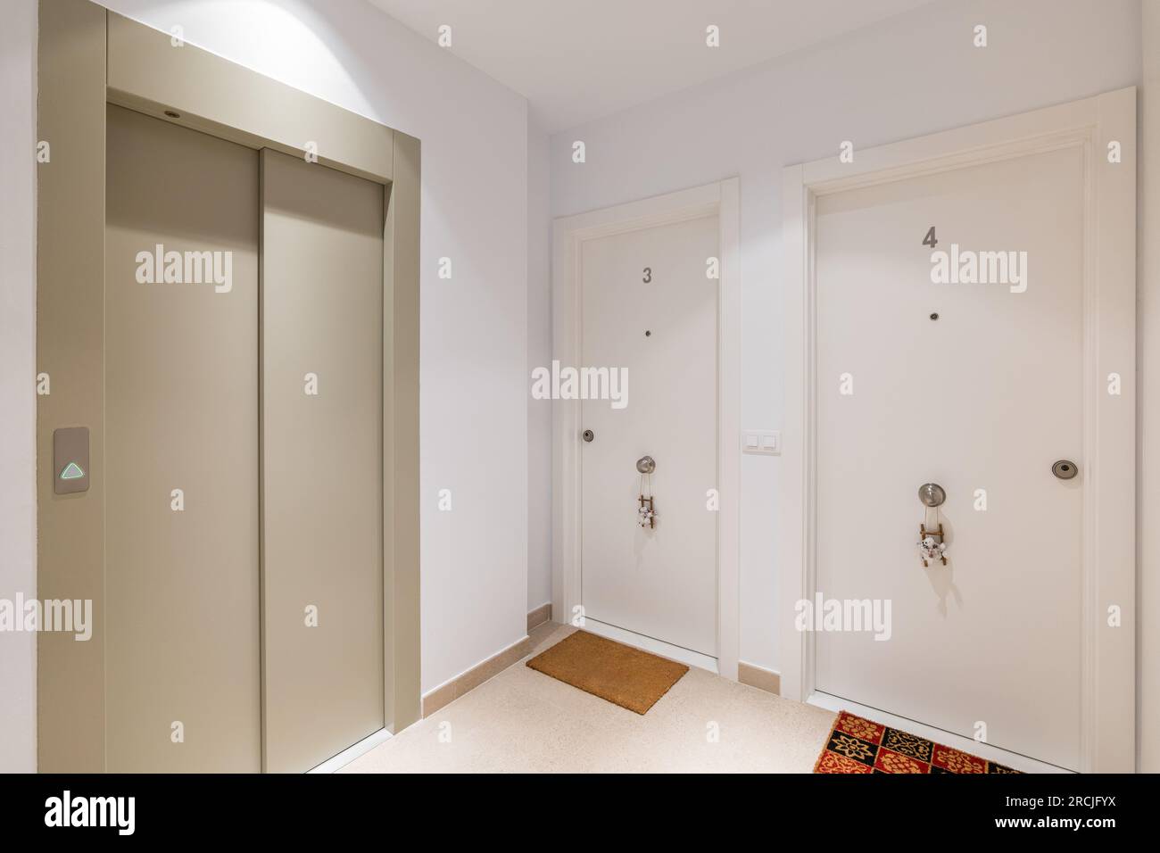 Hall space with a passenger lift and hotel rooms with the numbers three ...