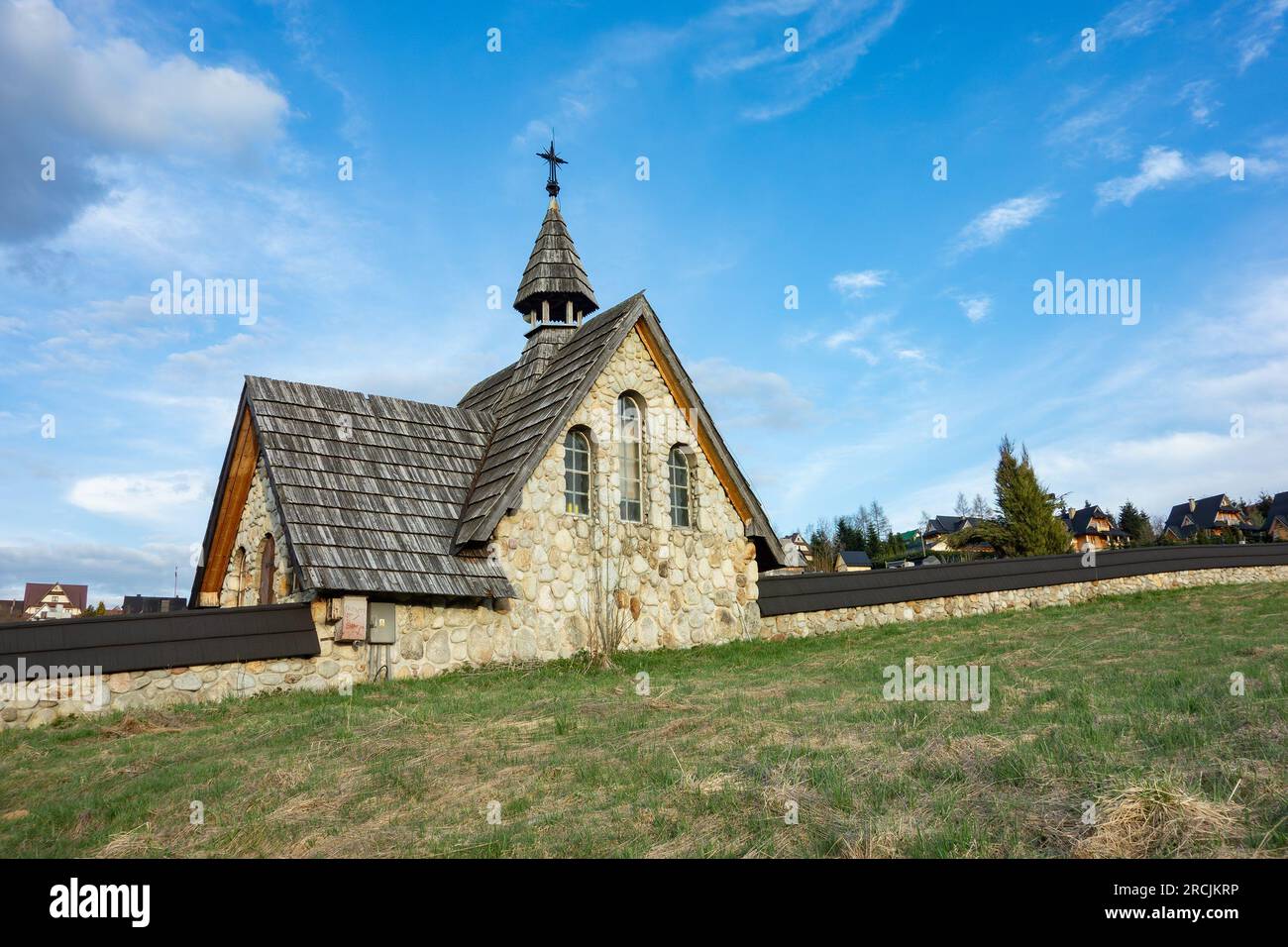 MURZASICHLE, POLAND - APRIL 28, 2023: Small stone chapel with a cross ...