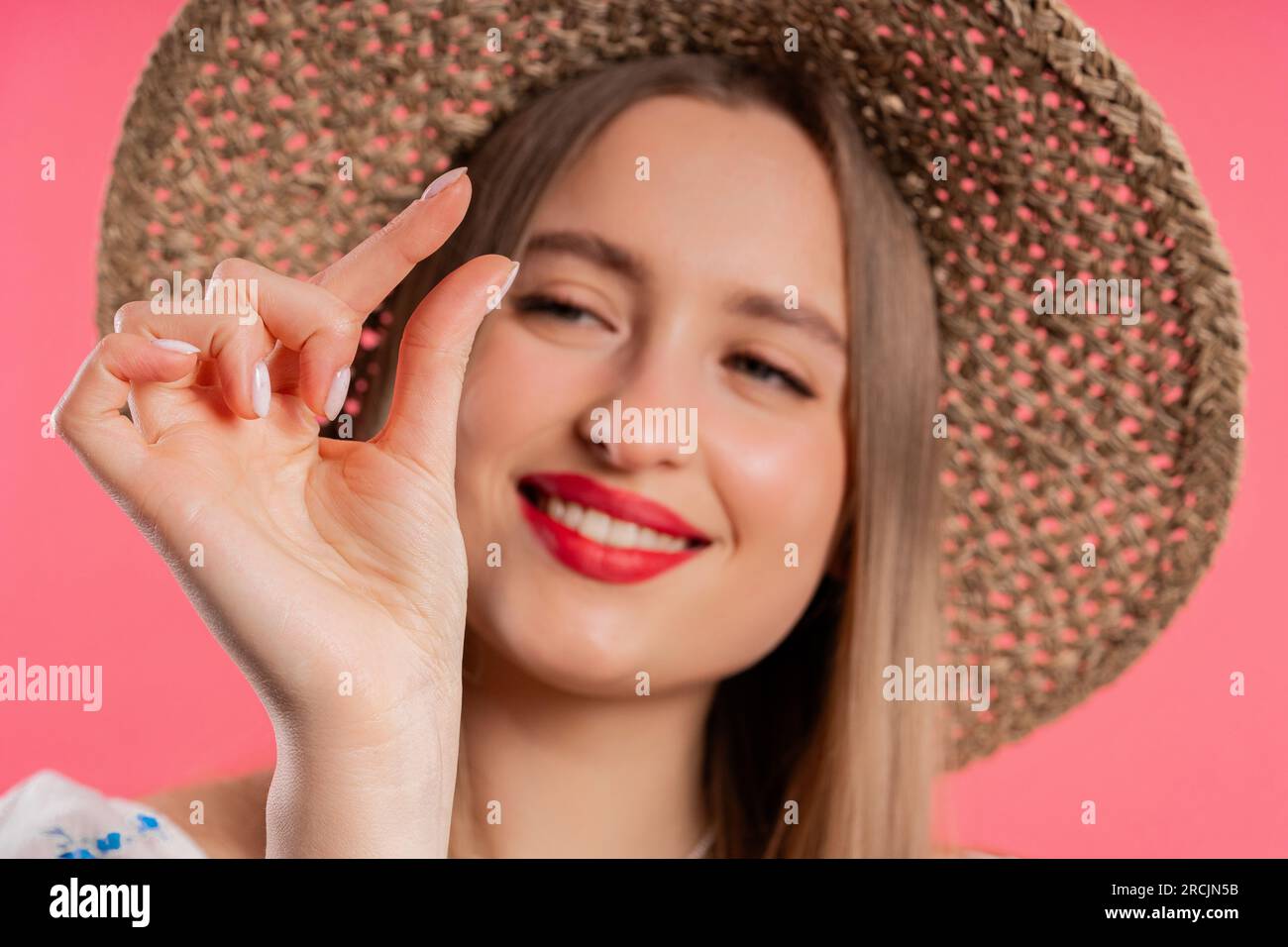 Young woman showing small invisible abstract subject, tiny object sizes ...