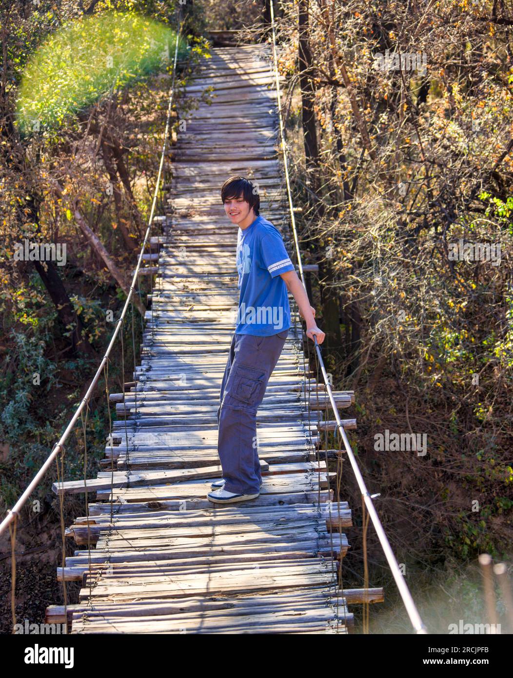 young adult crossing an old wooden bridge in the bush Stock Photo - Alamy