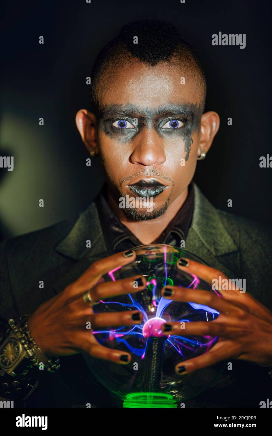 african american rapper with a plasma static electricity globe on dark ...
