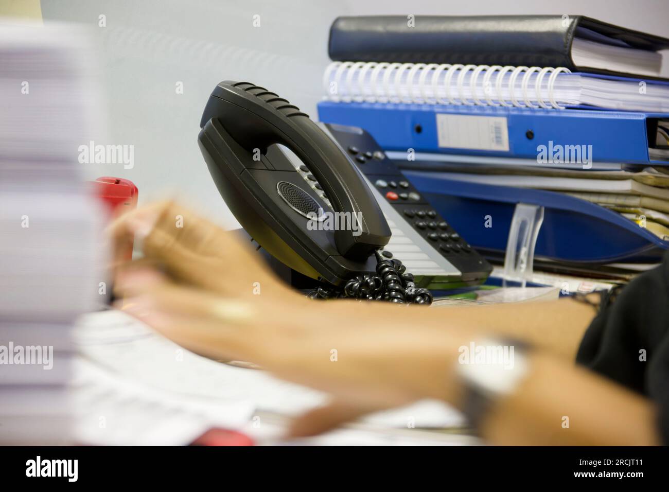 reception desk operator, phone line and pile of files Stock Photo - Alamy