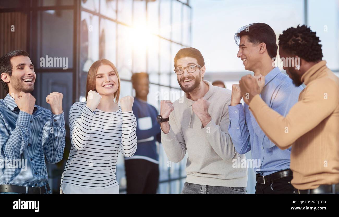 Business people celebrates and clench their fists in the air as a ...