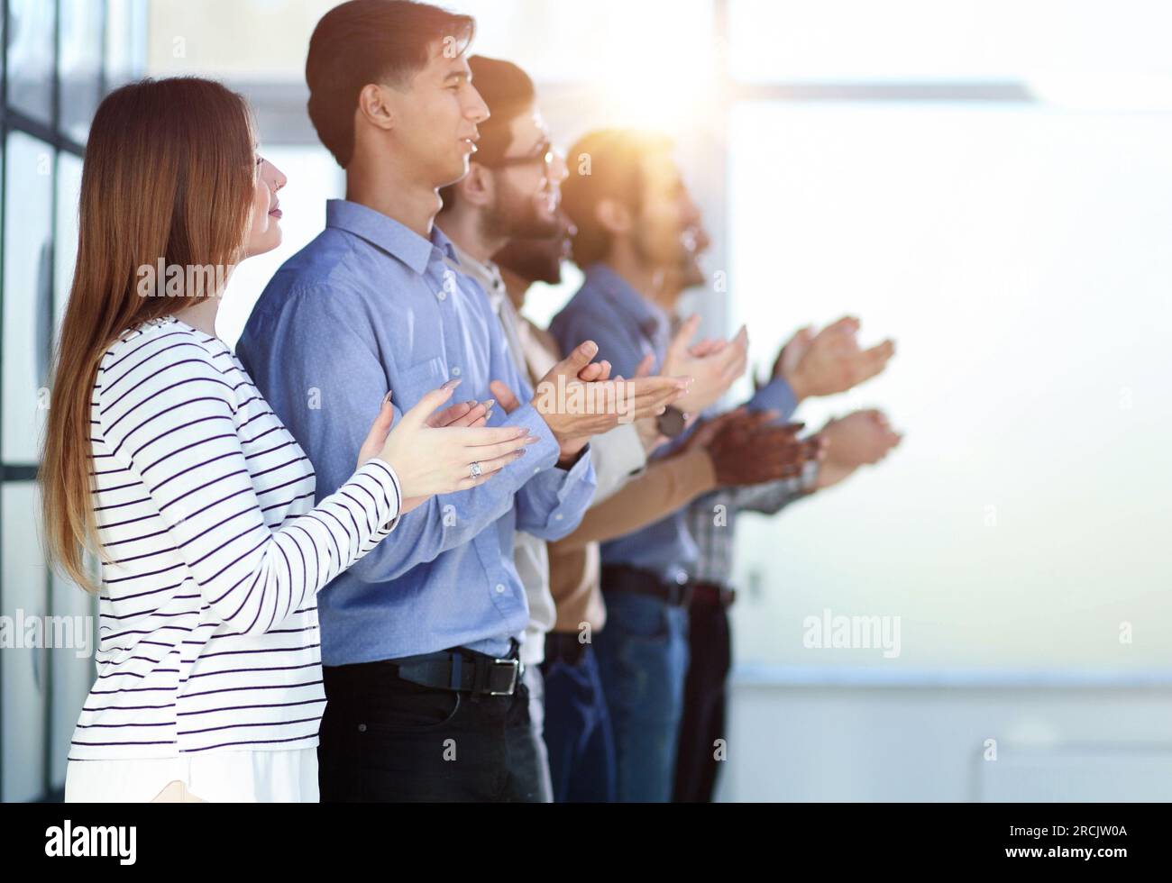 A group of people standing in a row clapping their hands Stock Photo ...