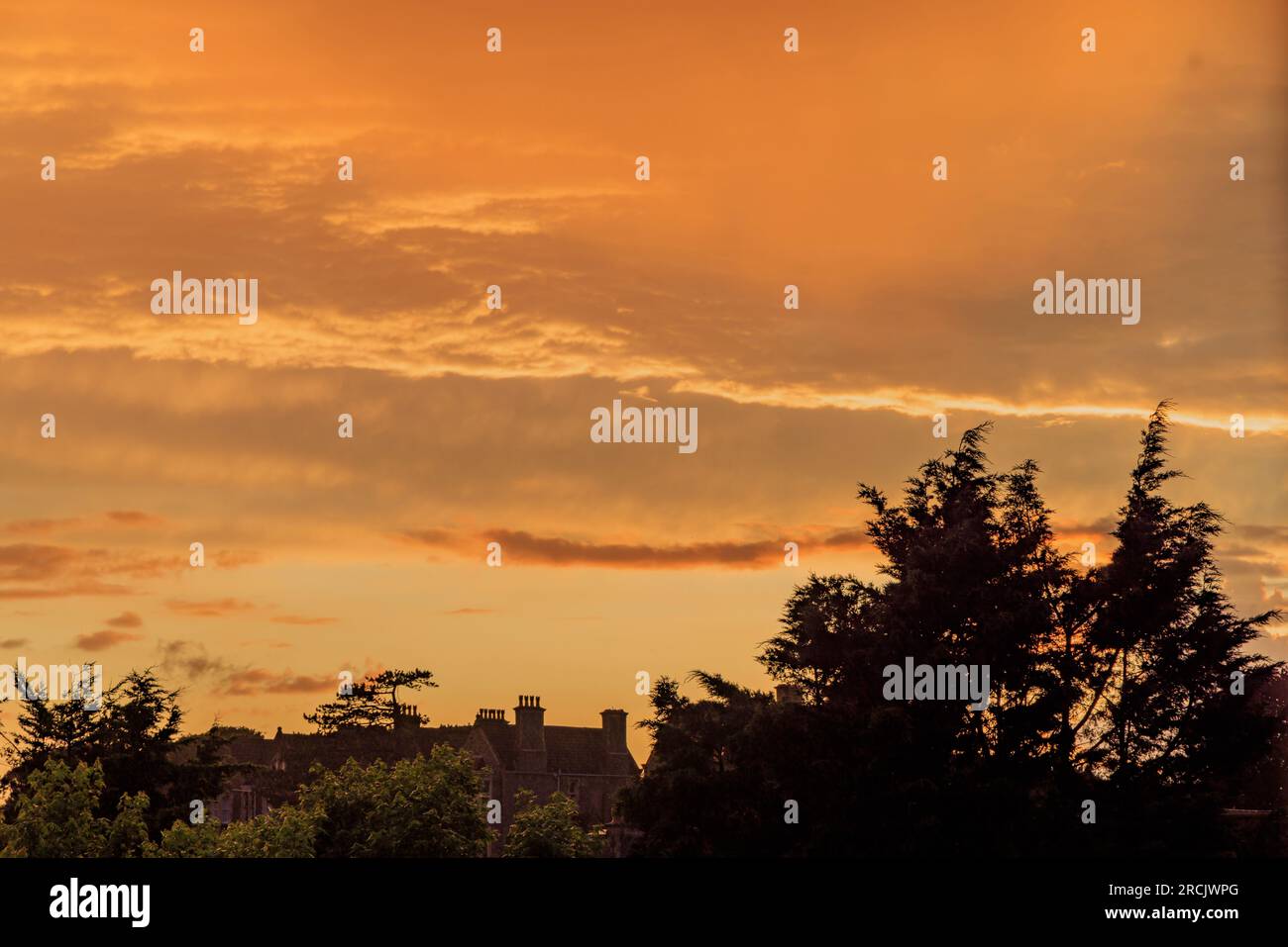 The setting sun lighting up the cloud cover Stock Photo - Alamy