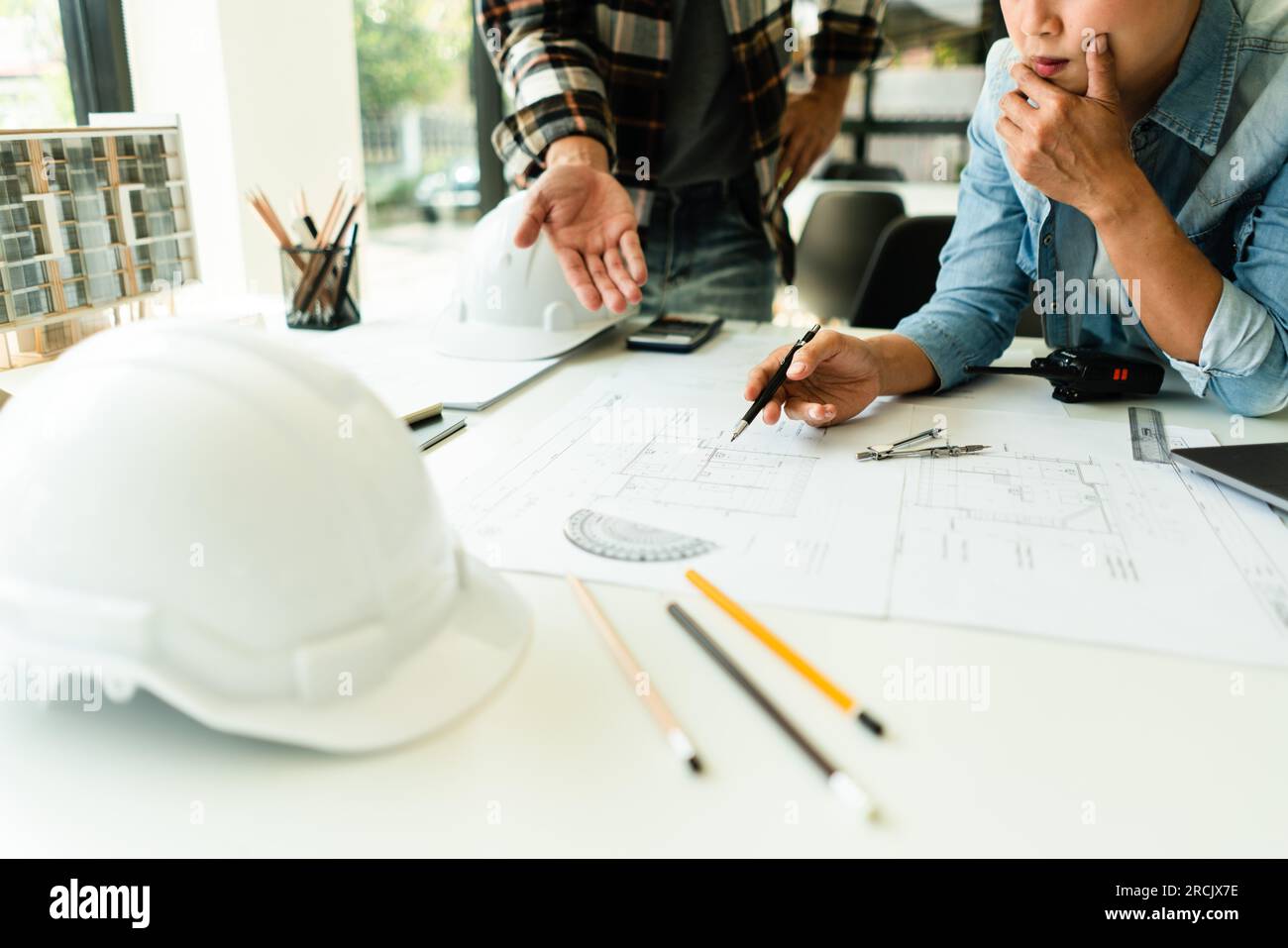 Two engineer working to discuss and brainstorming about blueprint of ...