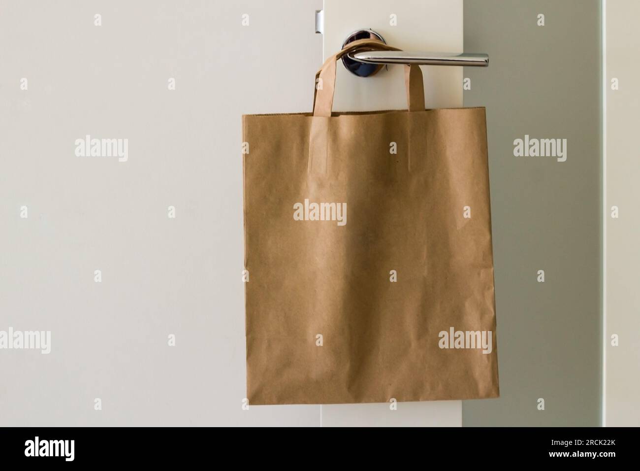 Empty shopping bag with brown kraft paper hanging on the door Stock ...