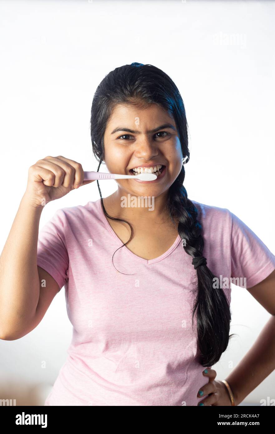 An Indian woman female girl brushing teeth on white background with ...