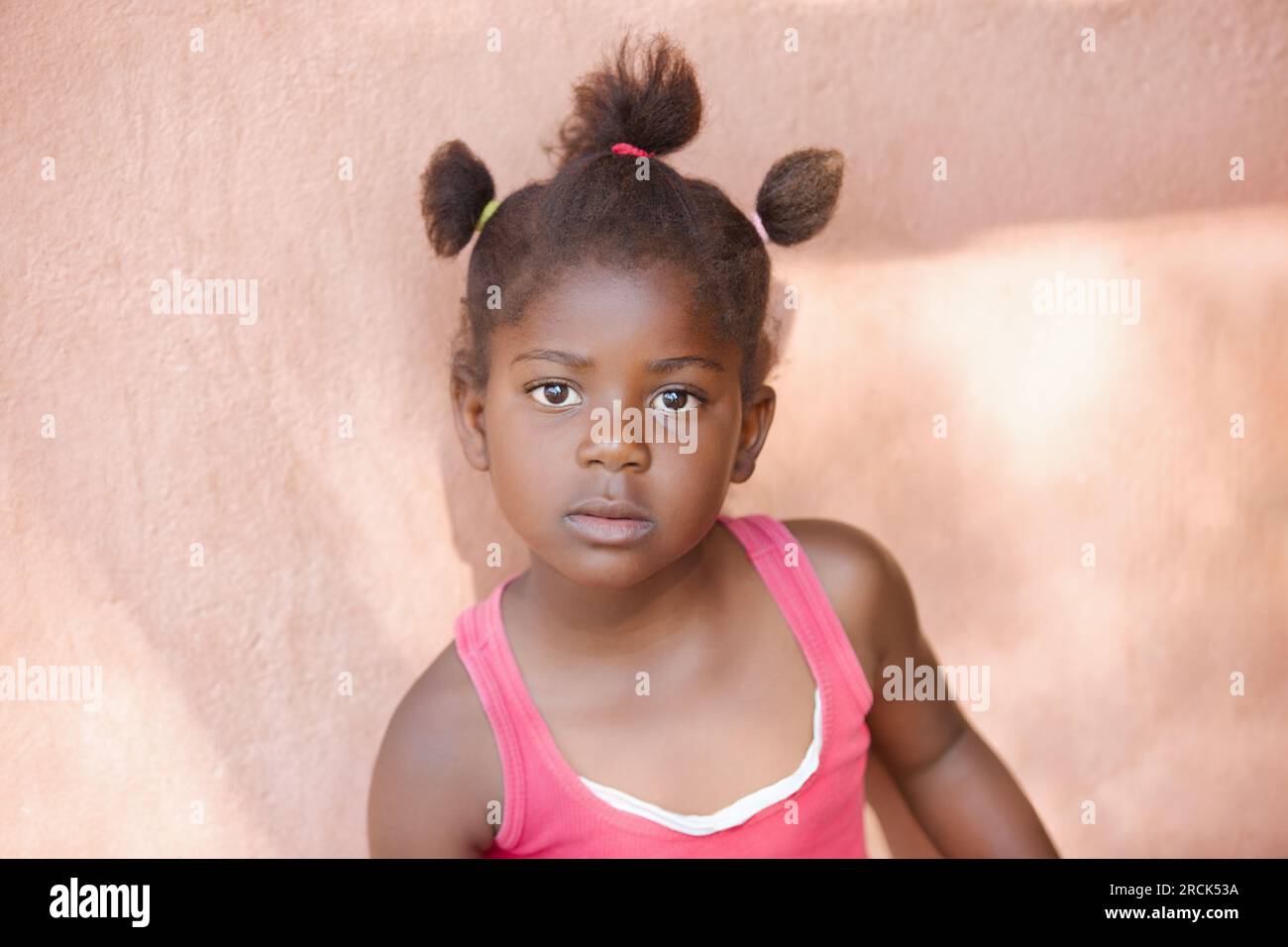 small african girl with ponytail braids standing in front of the house ...