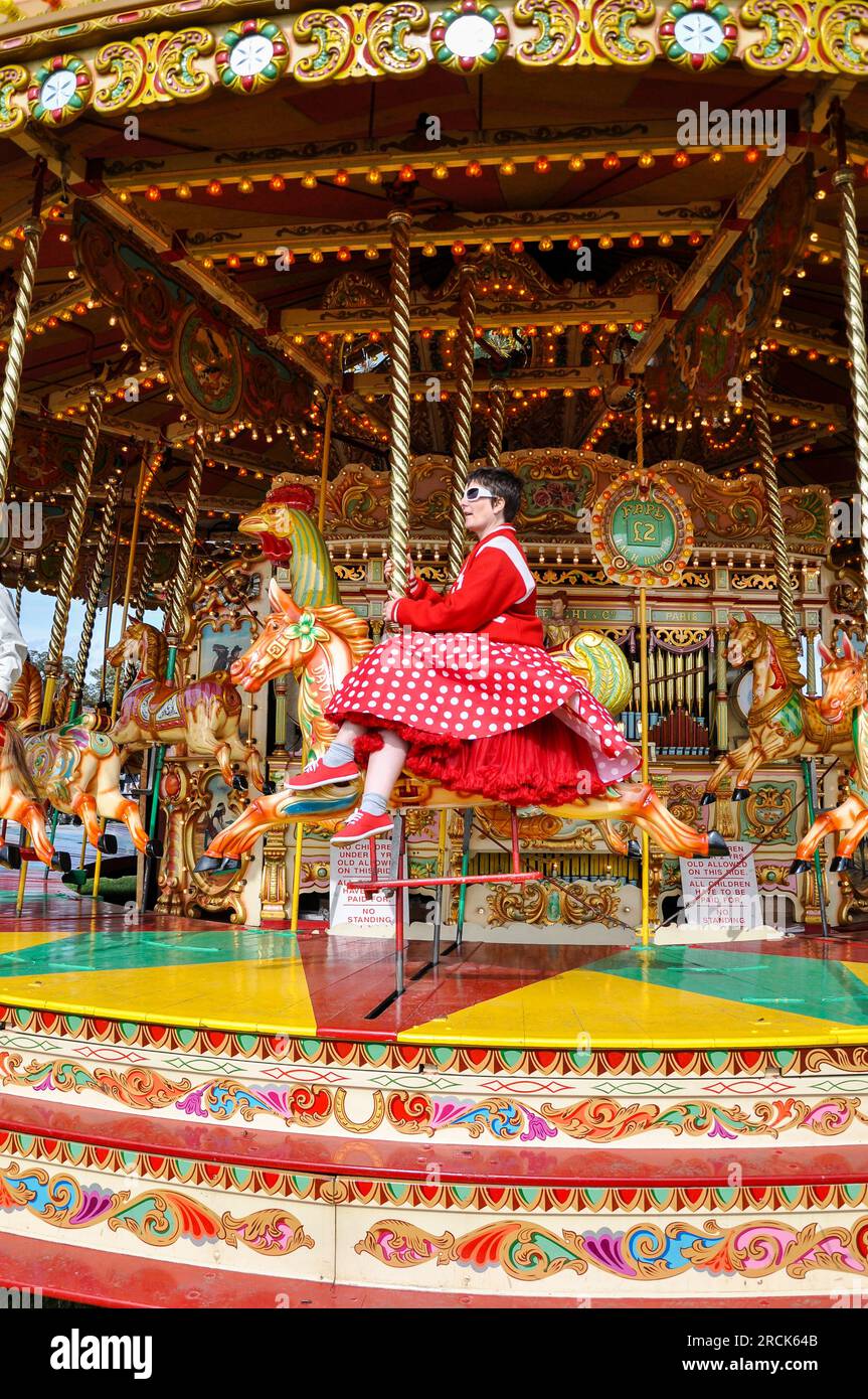 Female in period dress riding a Classic Carousel, Merry Go Round, at ...