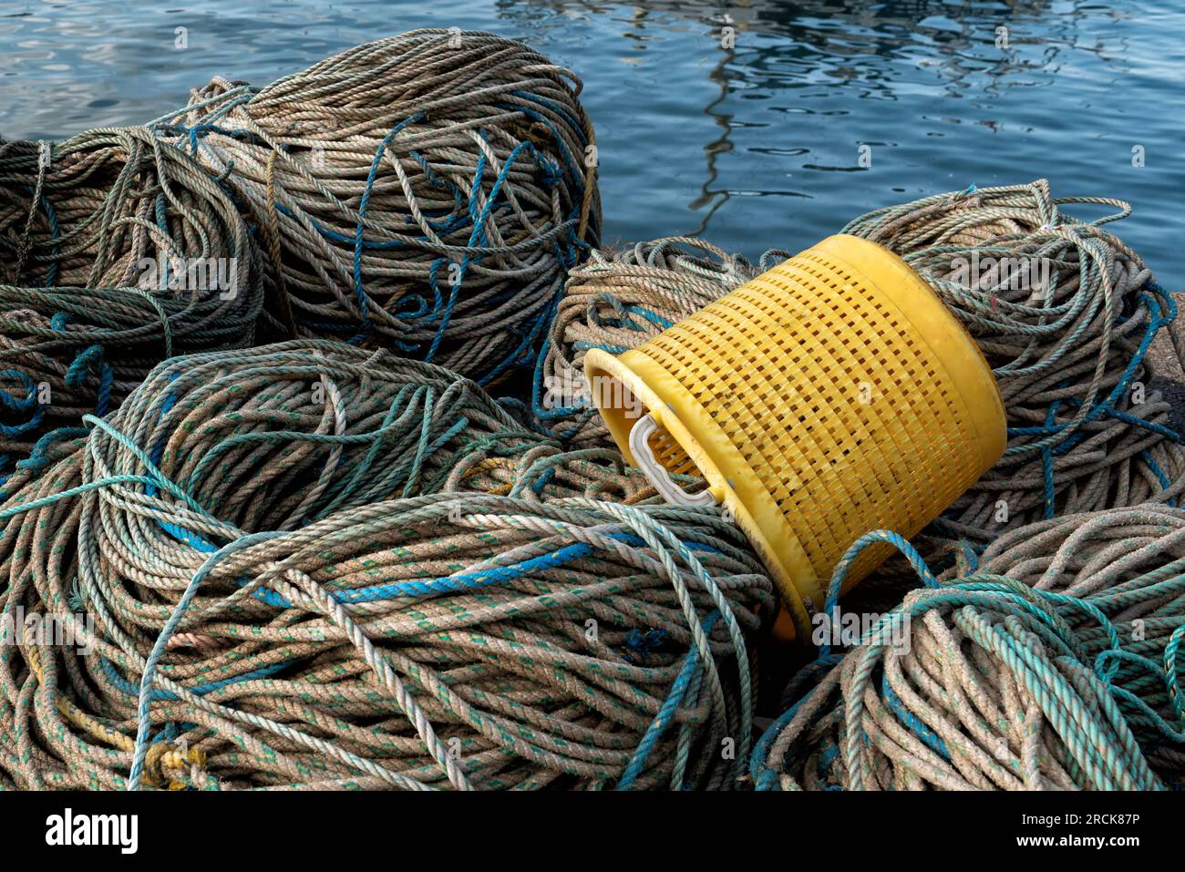 Fishing boat ropes and yellow bucket Stock Photo - Alamy