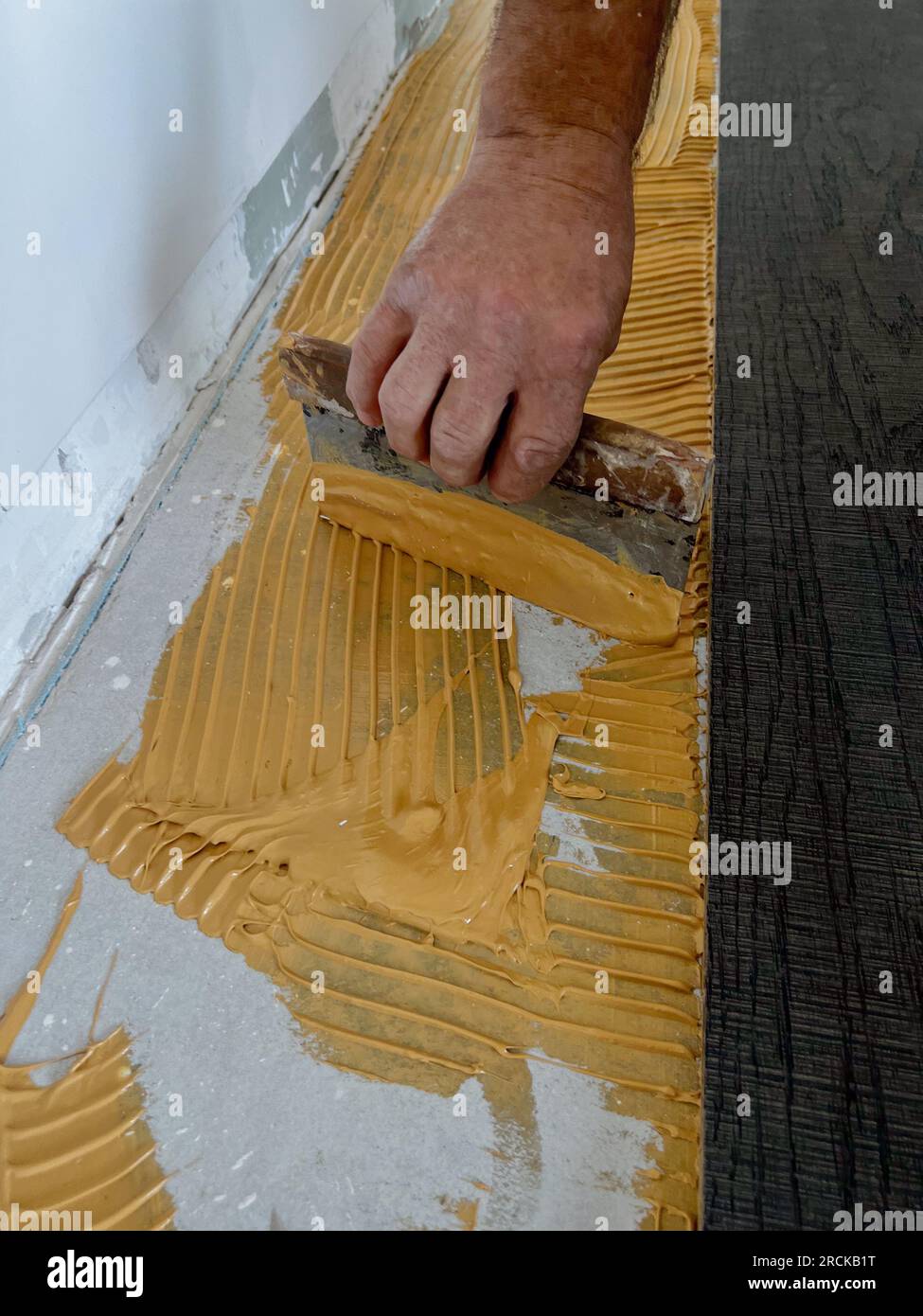 workers apply parquet glue to lay the Listone Giordano Stock Photo - Alamy