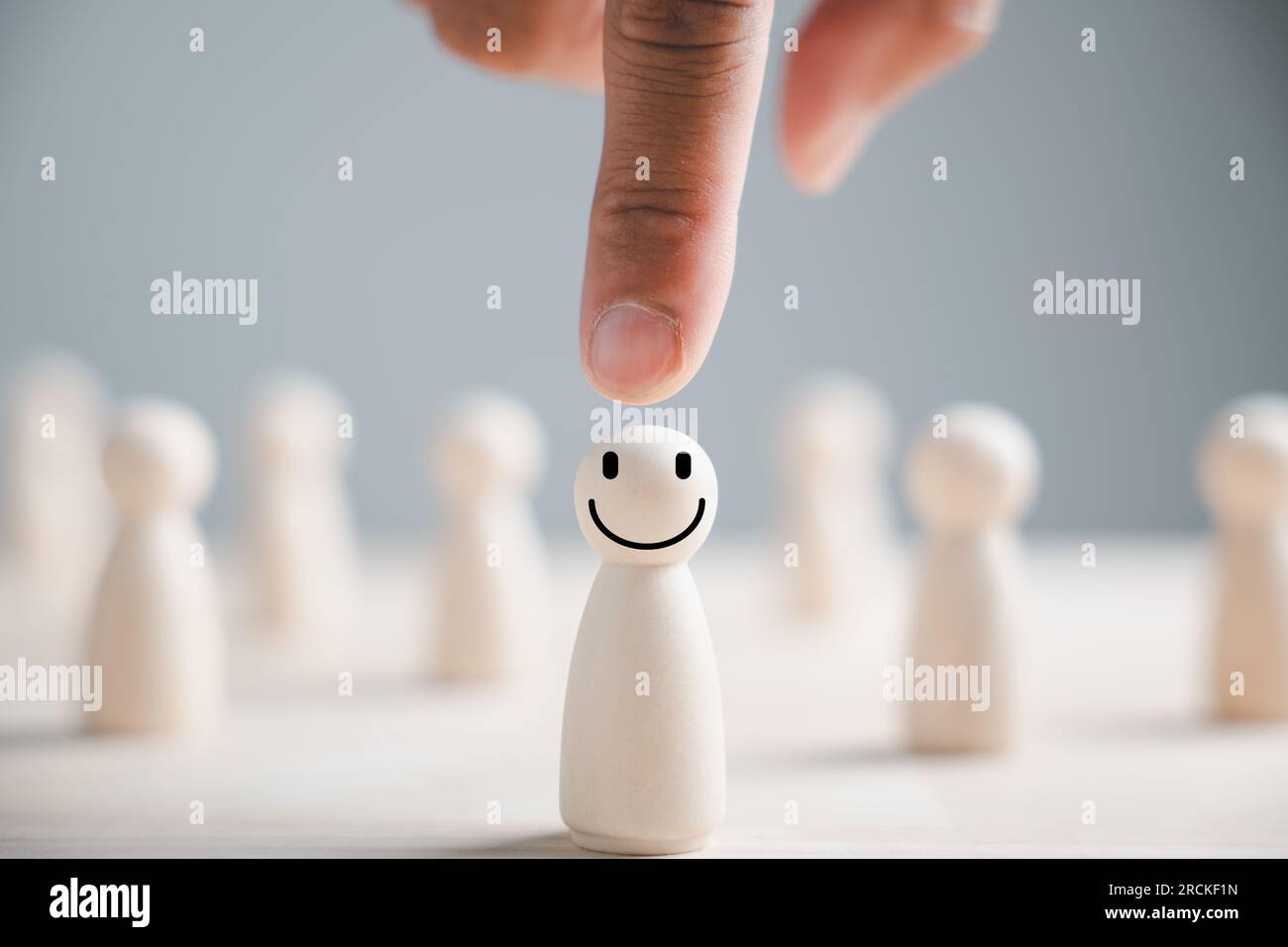 Hand choosing a wooden figure as the chosen leader from the crowd Stock ...