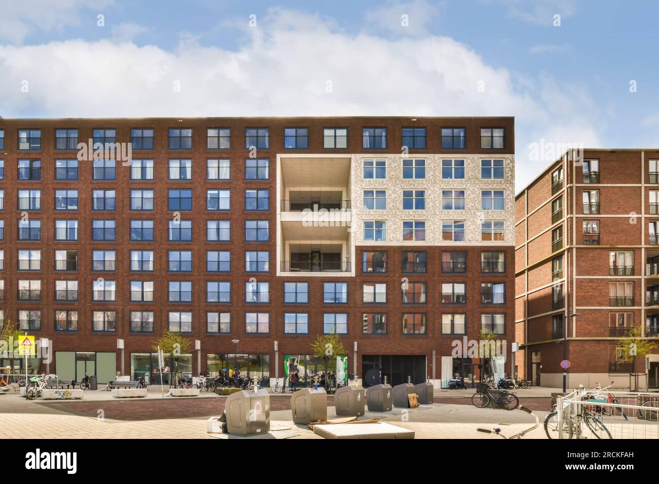an apartment building with many windows and people walking around in ...