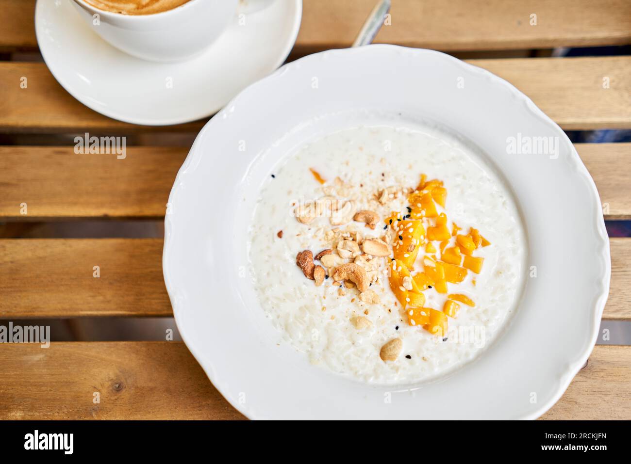 Breakfast in cafe on a sunny morning, on the summer veranda. Cappuccino ...