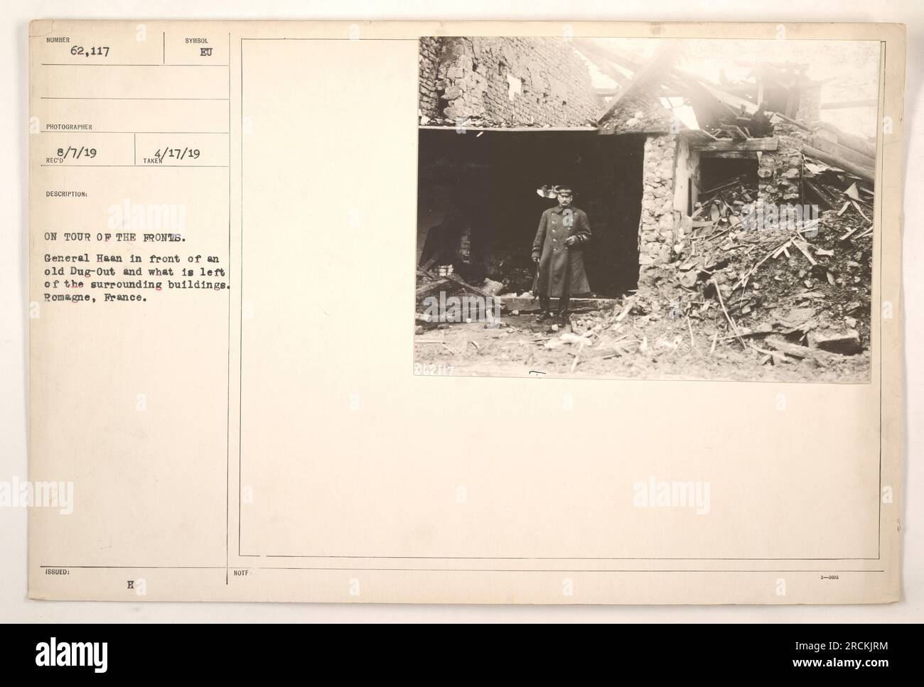 General Haan stands in front of a dilapidated dugout and the remnants ...