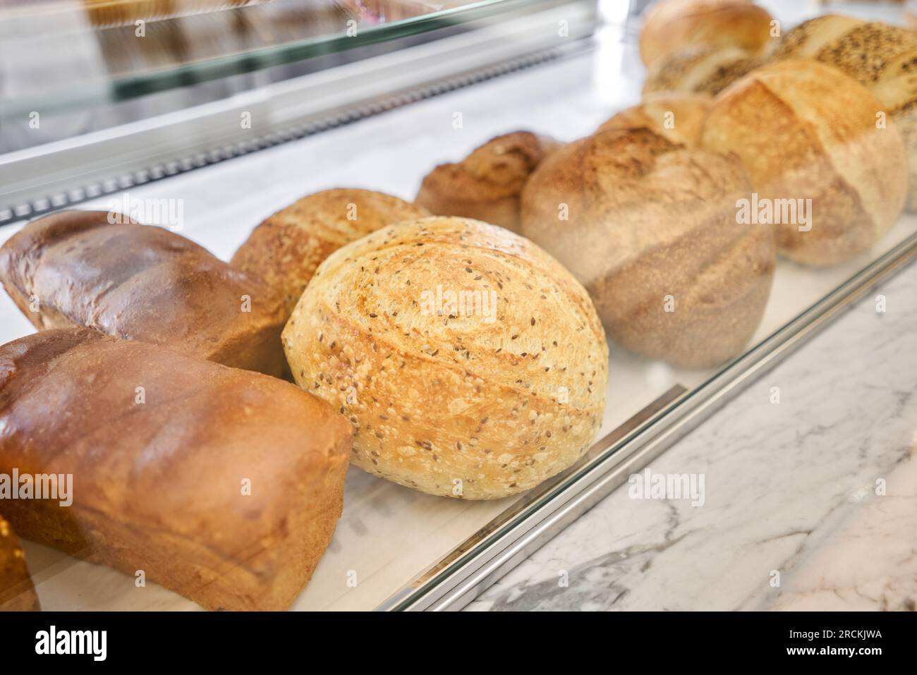 Different kinds of bread on the counter in the bakery shop. Fresh bread ...