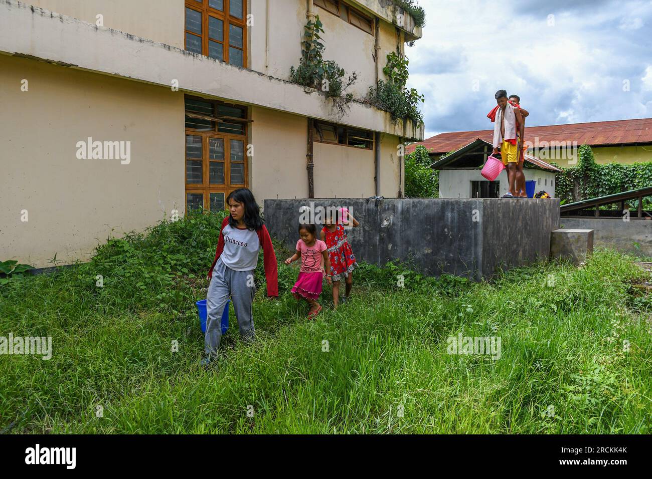 Imphal, India. 14th July, 2023. Children carry water at a relief camp ...