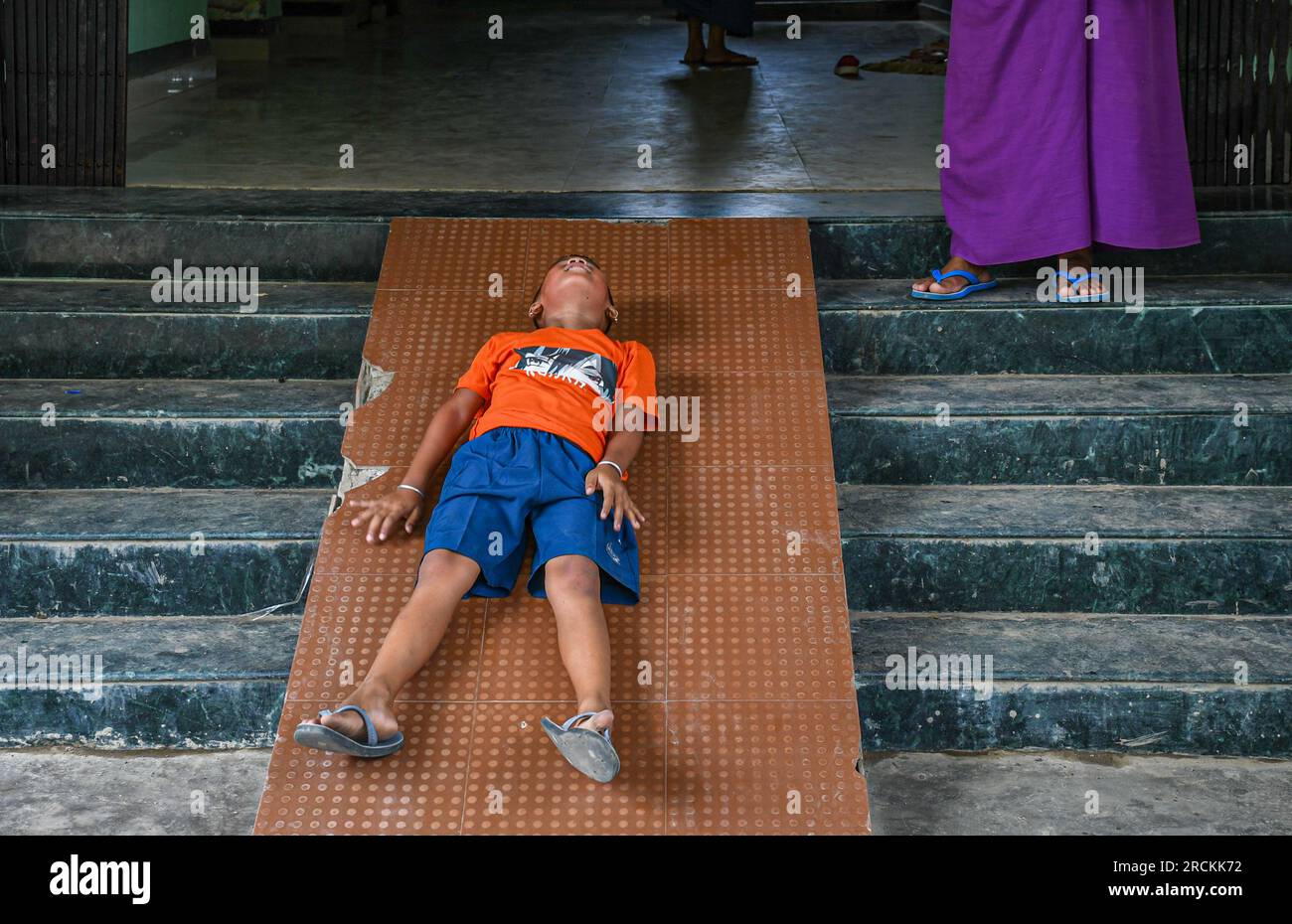 Imphal, India. 14th July, 2023. A boy plays with a slide on the ground ...
