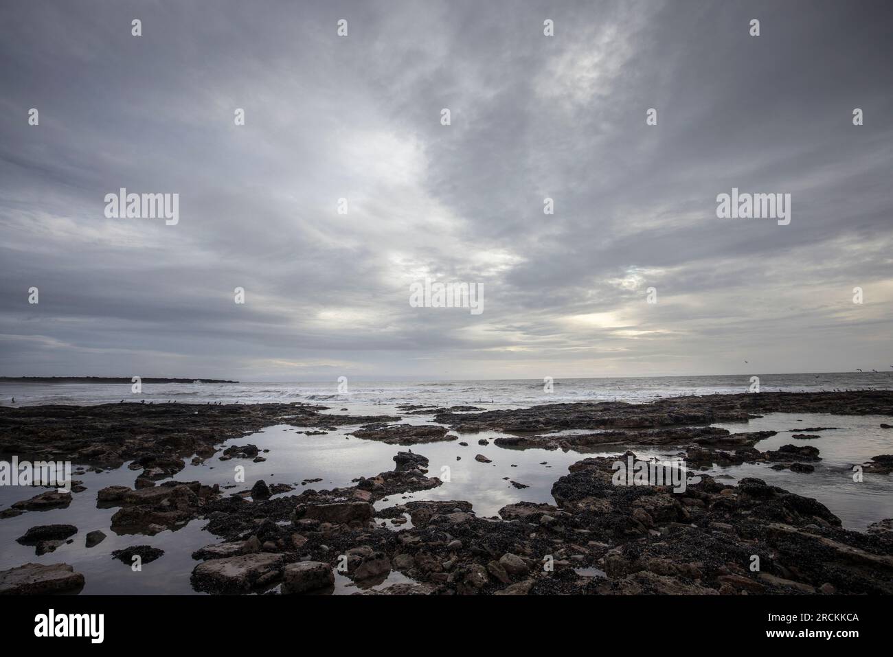 Rocky shore with clouds, Kenfig beach, Wales, UK Stock Photo - Alamy