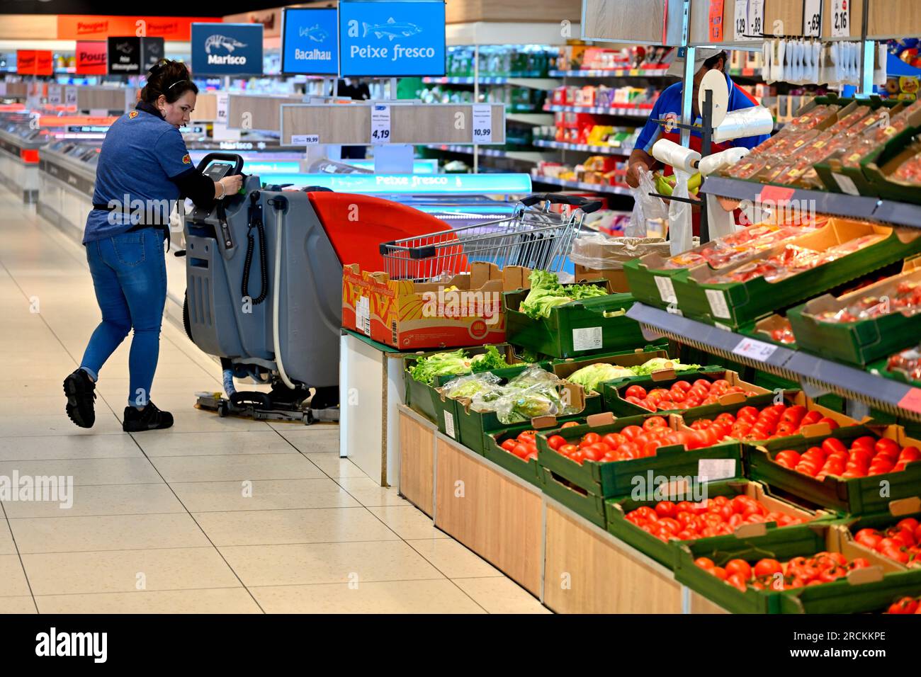 Inside Lidl store with staff cleaning the floor with large polishing ...